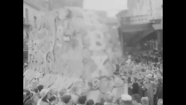 1950s:Parade float in middle of crowd. People dance in crowd. People in ...
