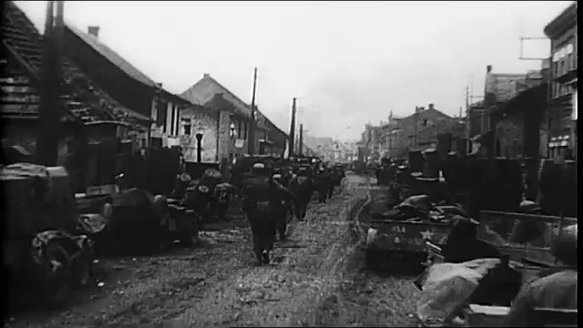 Germany 1940s: Soldiers walk through a village. Ruined buildings ...
