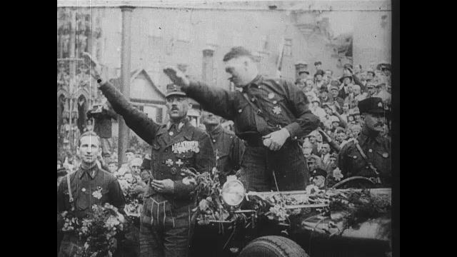 1930s Germany: Hitler speaks to soldiers and salutes. Soldiers salute ...