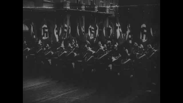1930s: German soldiers march down road holding Nazi flags. Nuremberg ...