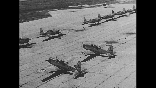1940s: Soldiers walk around fighter planes parked on concrete runway ...
