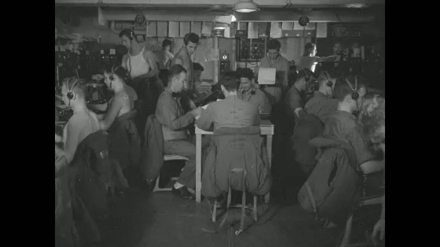 1940s: Group of sailors and radio operators below deck. Shirtless radio ...