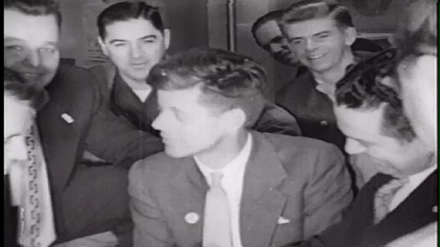 1950s: John F. Kennedy with crowd of men. Men cheering around Kennedy ...
