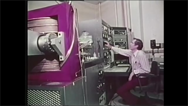 1970s: Scientists look through window of containment box at moon rock ...