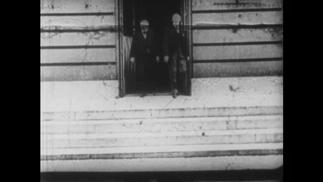 1950s: men exit door onto steps and shake hands. Adolf Hitler walks and ...