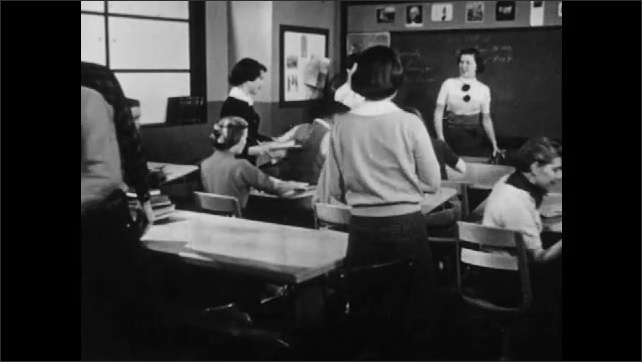 1950s: High school classroom. Students and teacher stand. Students ...