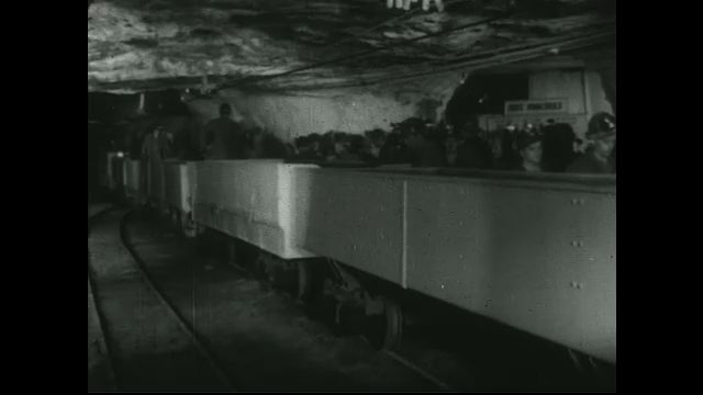 1940s: Miners climb aboard underground cart. Miners travel along mine ...