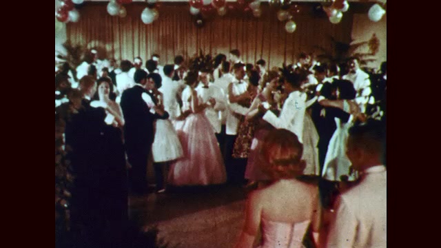 1950s: People at dance. Blind man in chair reaches for glass of water ...