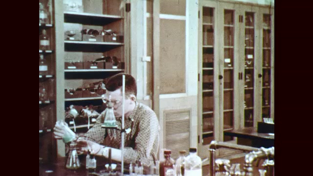 1950s: Boy enters chemistry lab, sits at table, puts on safety glasses ...