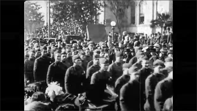 1920s: People celebrating in large parade. Brass band marches down ...