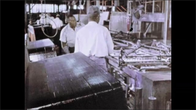 1960s: Two men in factory pick up large sheet of glass from stack and ...