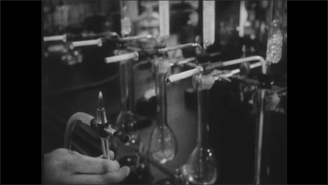 1950s: UNITED STATES: cigarette in hand. Fingers hold match by ...