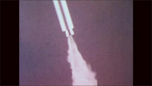 1960s: Model rocket ship flies through sky. Smoke plumes from rocket ...