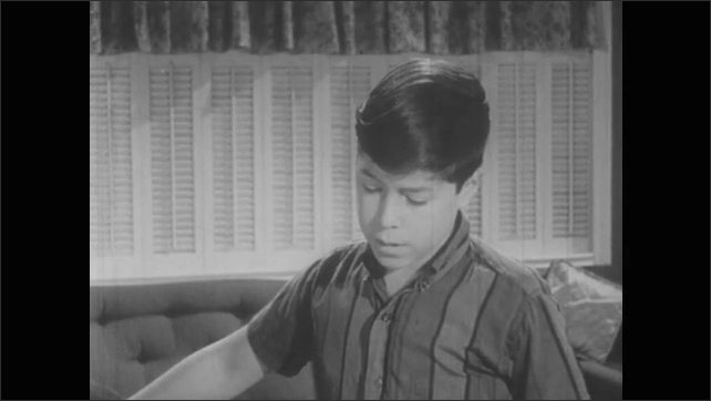 1950s: Person points to chart with pen. Boy stands, concentrates, talks ...