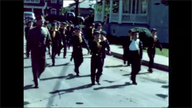 1950s: Boys in uniforms march down the street. – Archival Footage
