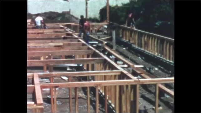 1950s: People with shovels help move concrete into mold of wood walls ...
